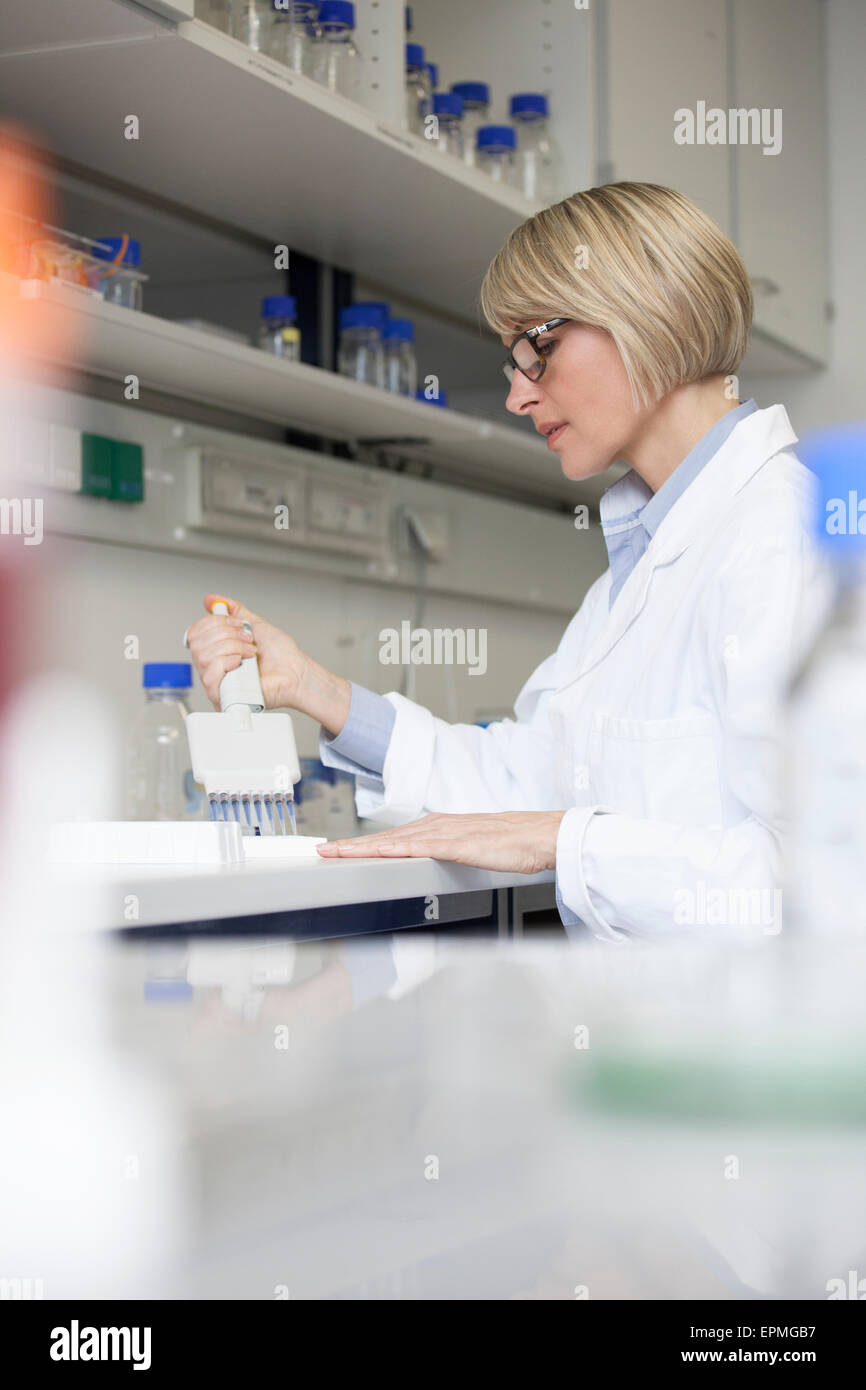 Scientist pouring liquid in test tube Stock Photo - Alamy
