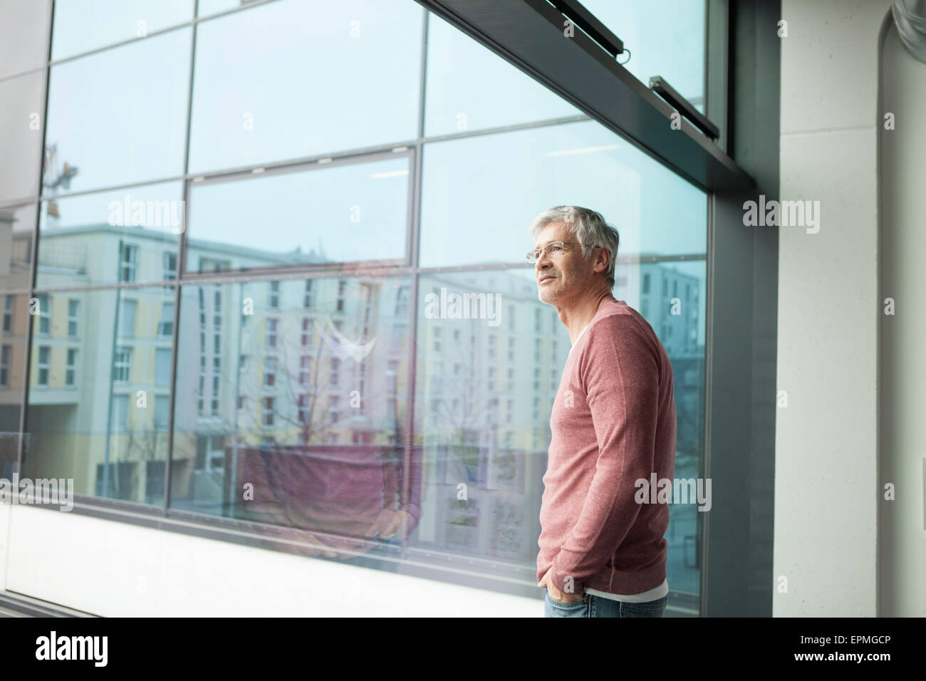 Man looking through window Stock Photo - Alamy