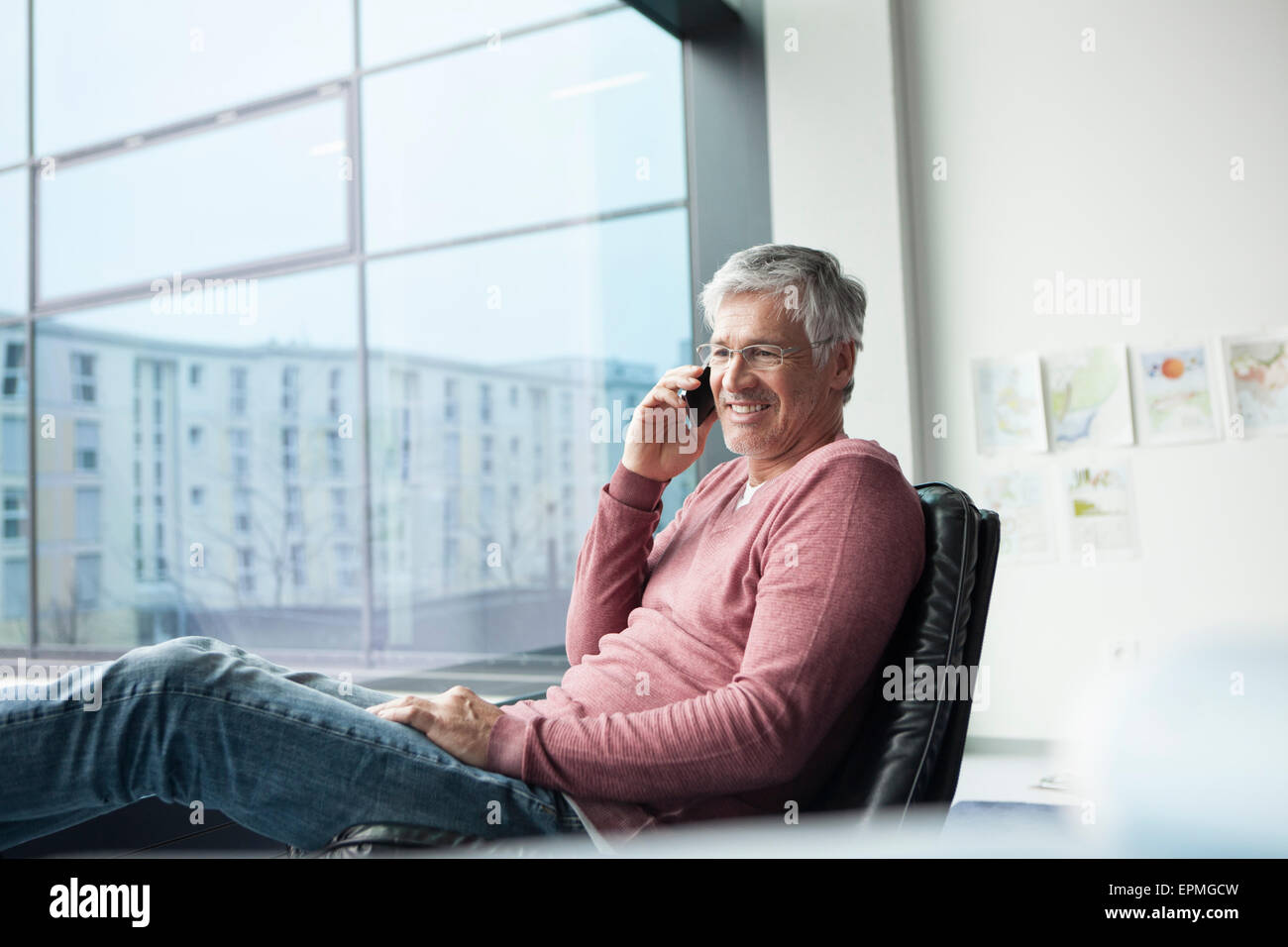 Man sitting in a leather chair telephoning with smartphone Stock Photo ...