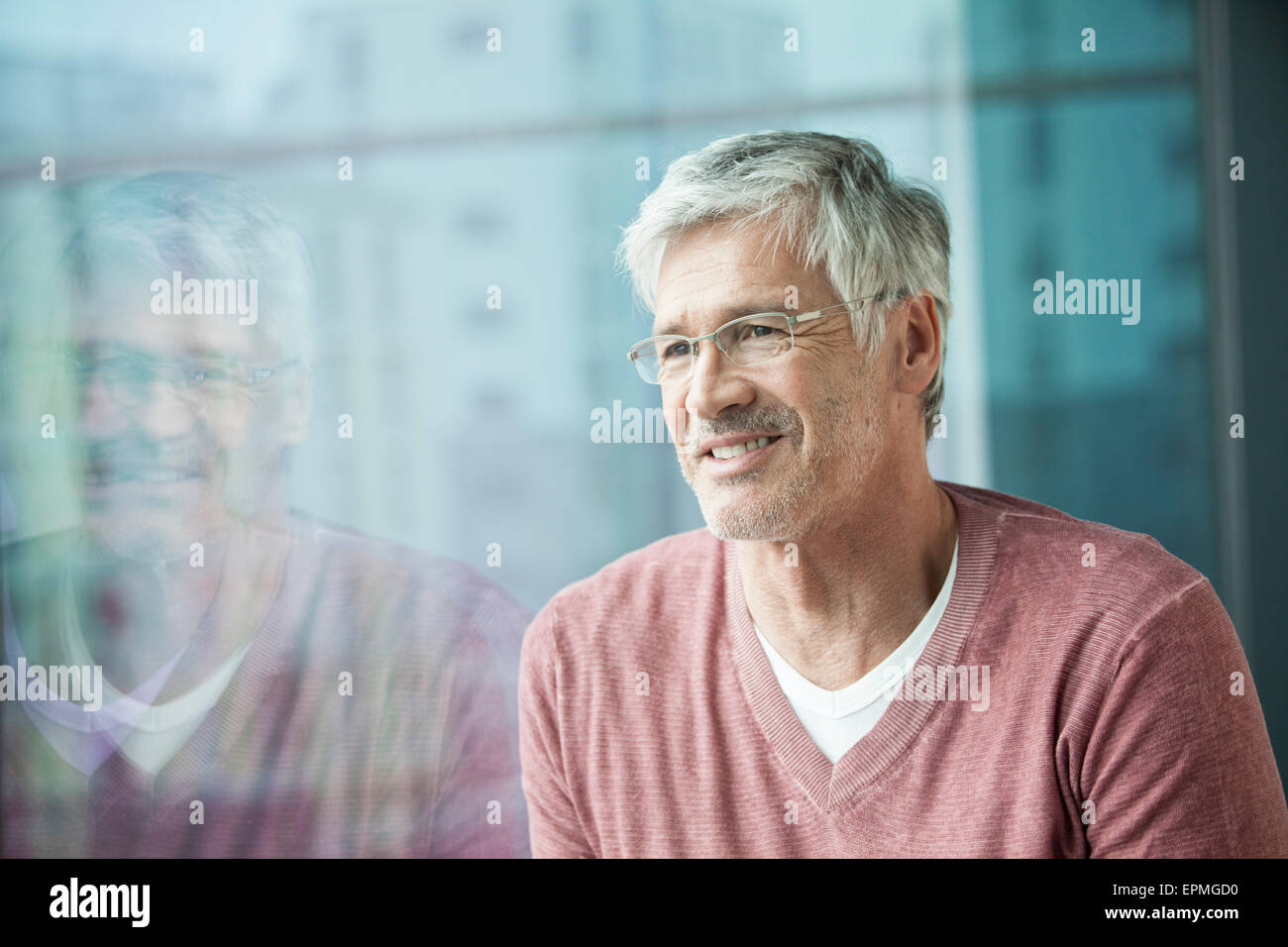 Portrait of smiling man looking through window Stock Photo - Alamy