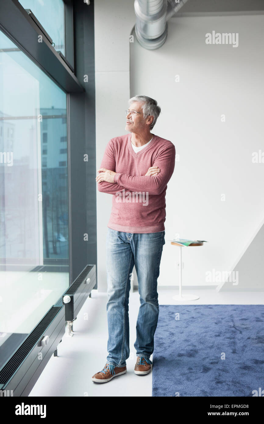 Pensive man looking through window Stock Photo - Alamy