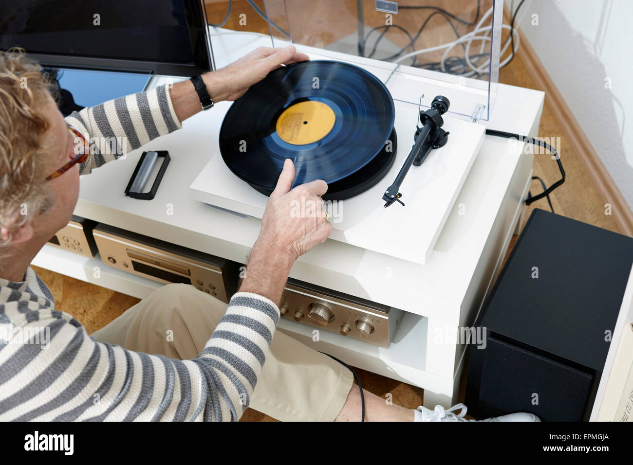 Senior man putting on some music Stock Photo - Alamy