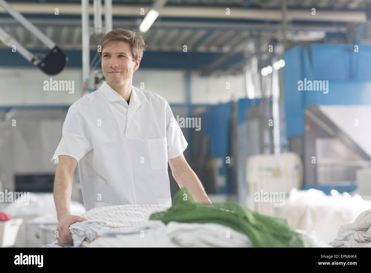 Smiling worker in laundry Stock Photo - Alamy