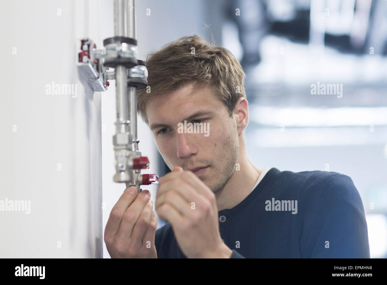 Technician adjusting lever at pipe Stock Photo - Alamy
