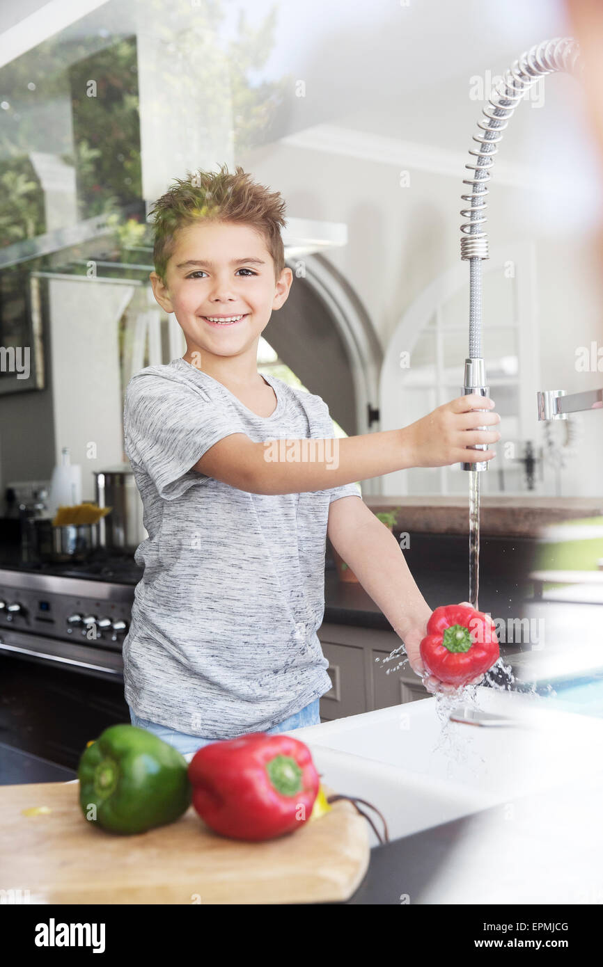 Boy washing vegetables in kitchen Stock Photo - Alamy