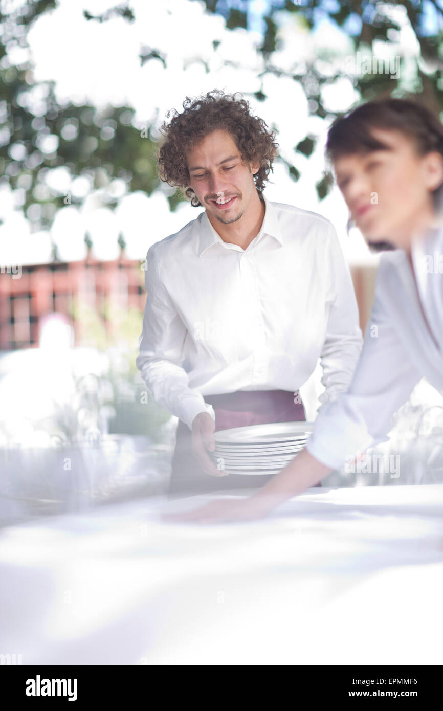 Waiters setting up an outdoor restaurant table Stock Photo - Alamy