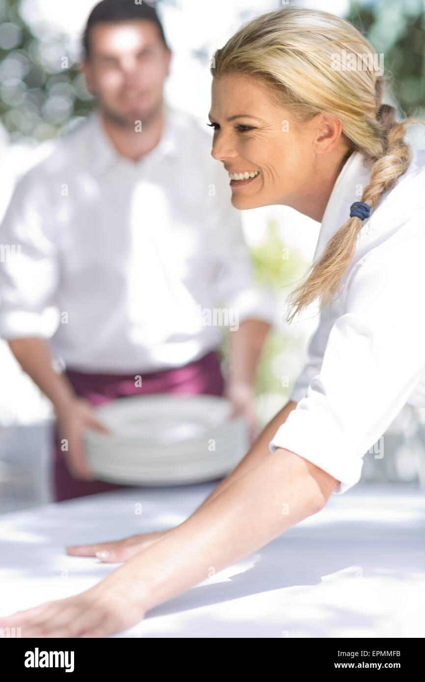 Waiters setting up an outdoor restaurant table Stock Photo - Alamy