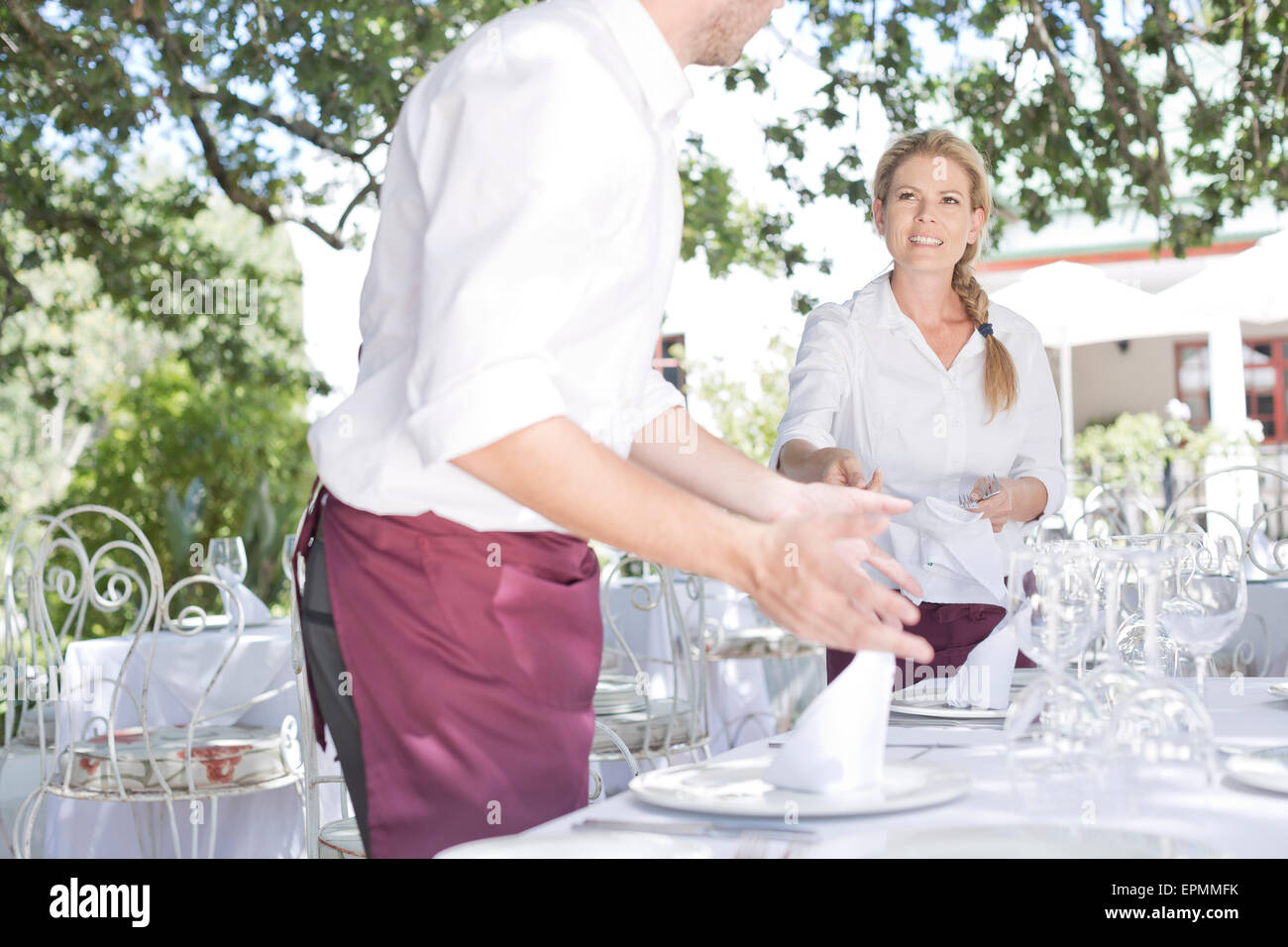 Waiters setting up an outdoor restaurant table Stock Photo - Alamy