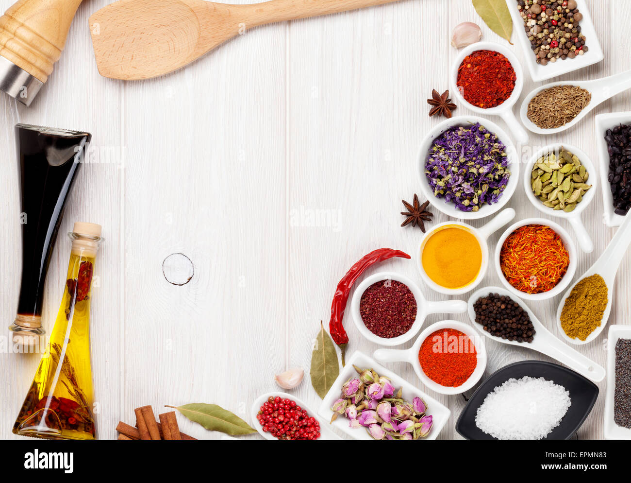Various spices and condiments on white wooden background. Top view with ...