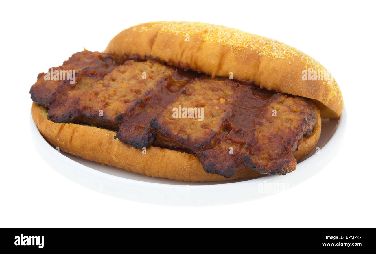 A cooked pork rib sandwich with barbecue sauce made with a white bun on ...