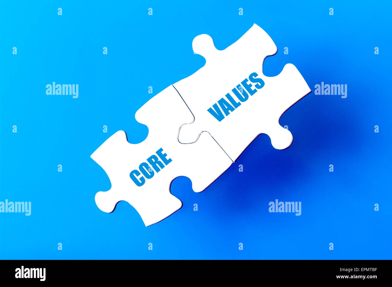 Connected puzzle pieces with text CORE VALUES isolated over blue ...