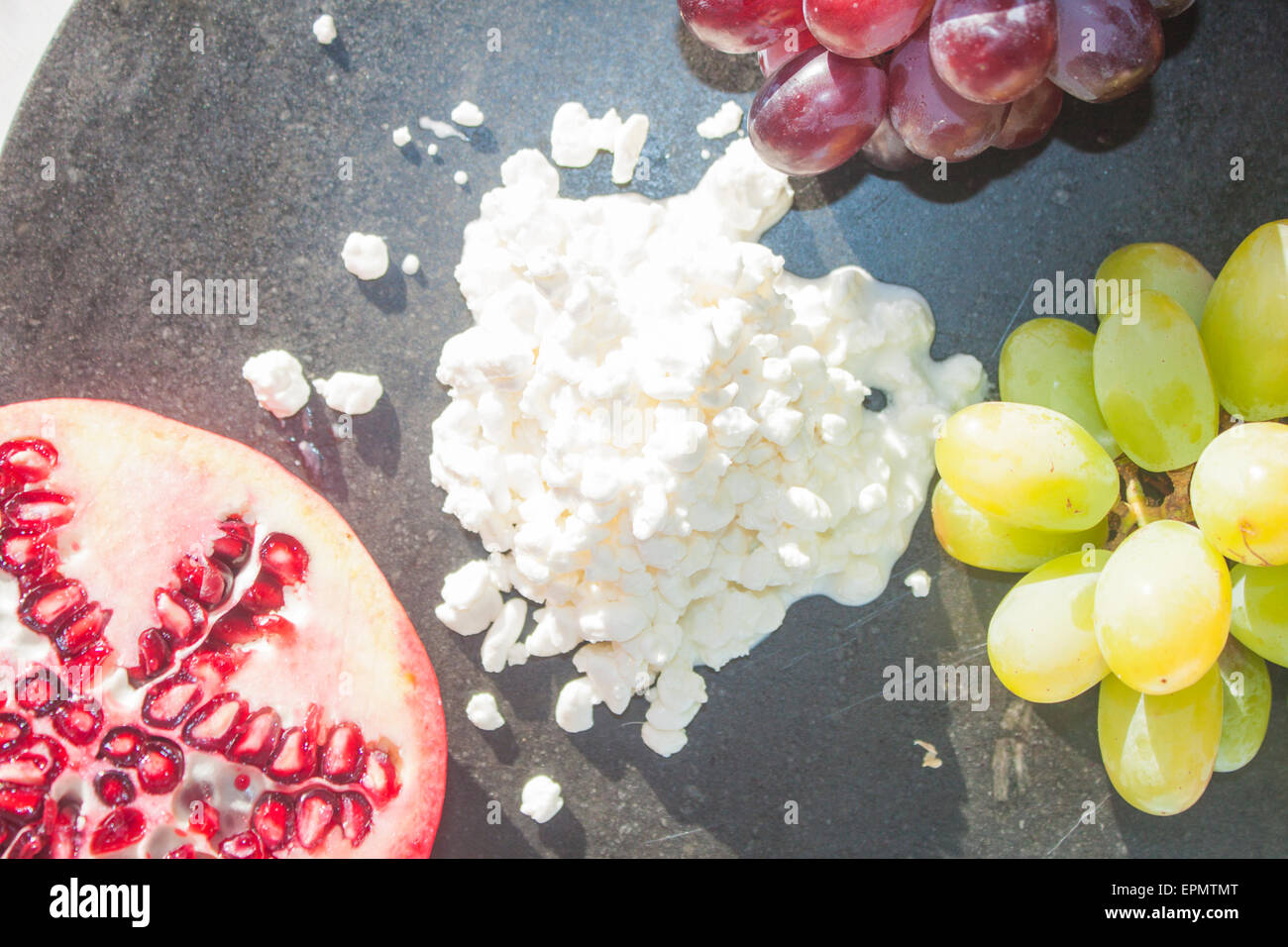 White cottage cheese, near pomegranate and grapes Stock Photo - Alamy