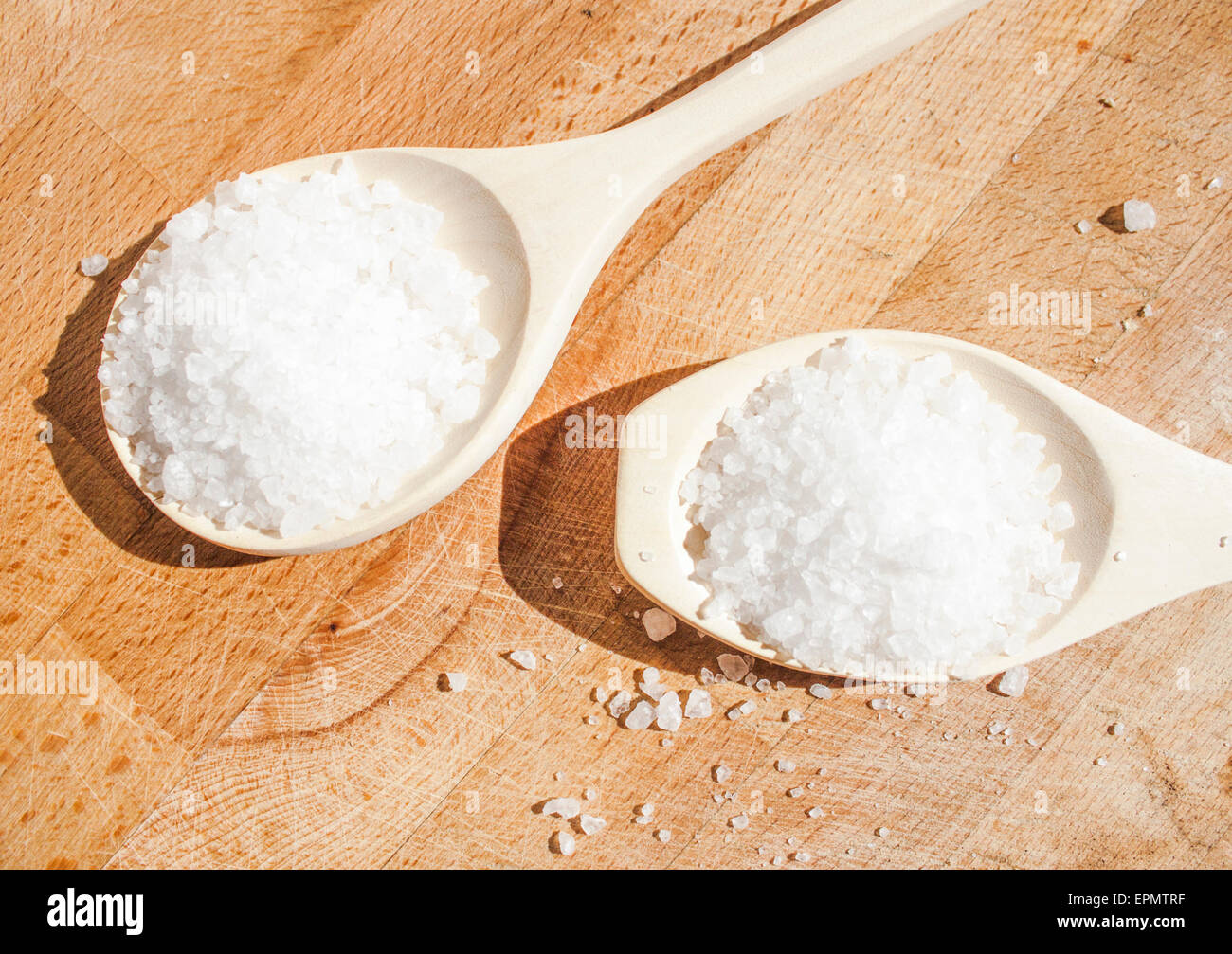 Two spoons full of white rock salt, on wooden background Stock Photo ...
