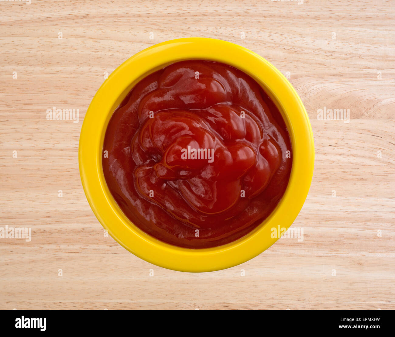Top view of a small colorful yellow portion bowl filled with ketchup on ...