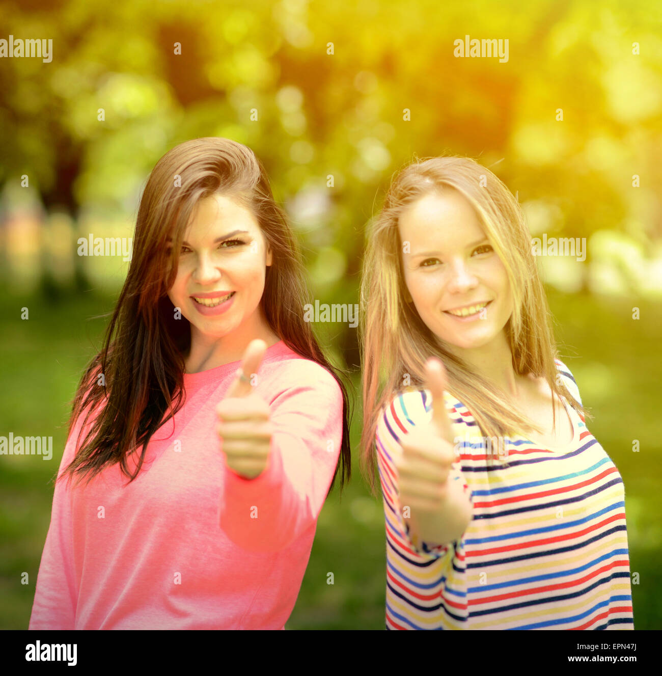 Young girls showing thumbs up Stock Photo - Alamy