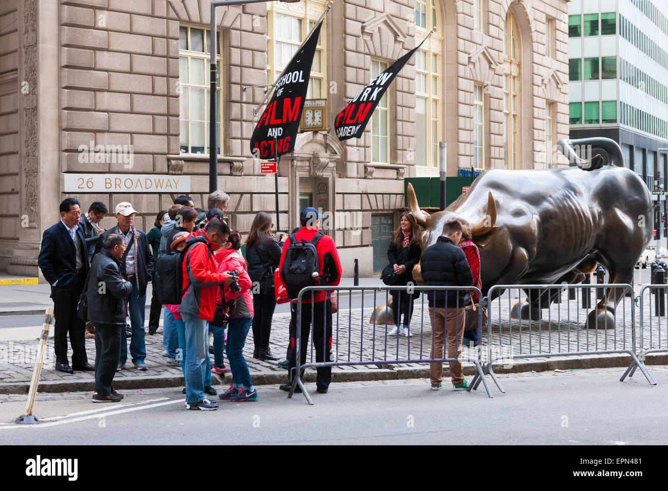 Tourists pose for pictures by the Charging Bull statue on Broadway in ...