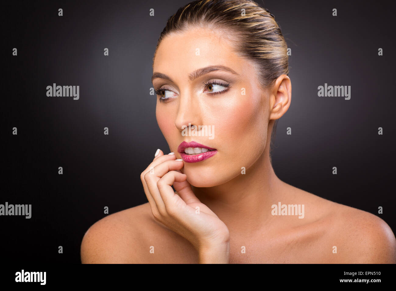 attractive young woman looking to the side on black background Stock ...