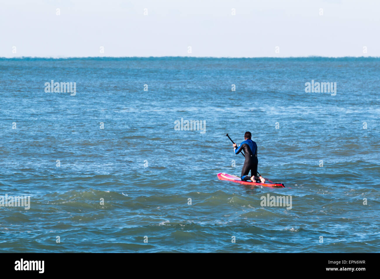 man paddleboarding on red board Stock Photo - Alamy