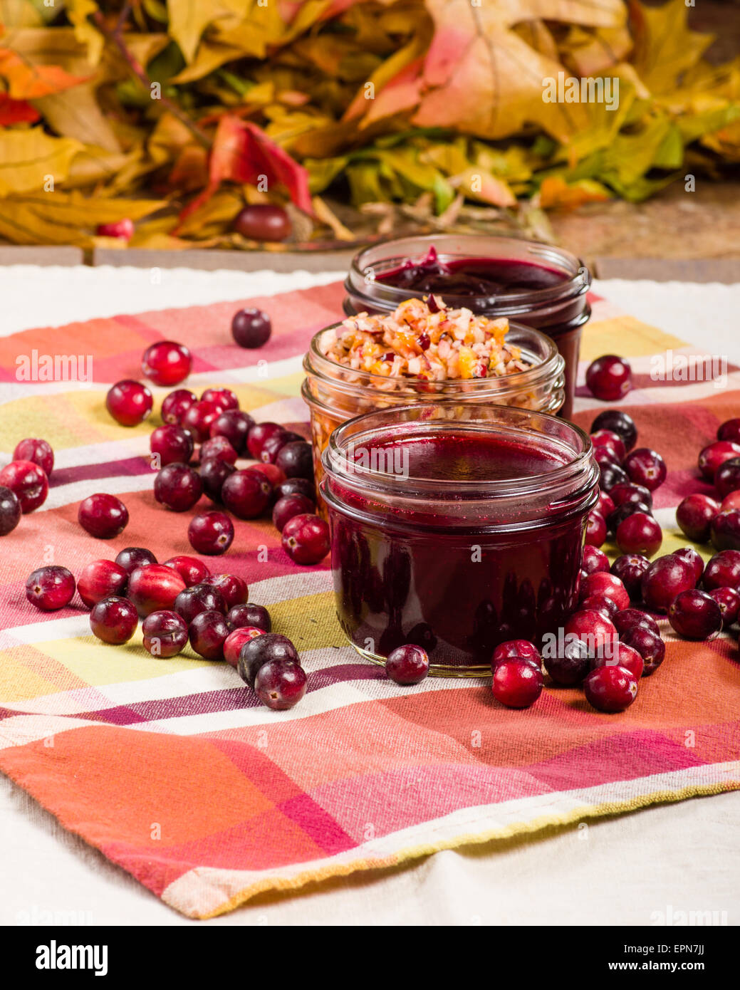 Jars of cranberry sauce with cranberries and apple relish on a table ...