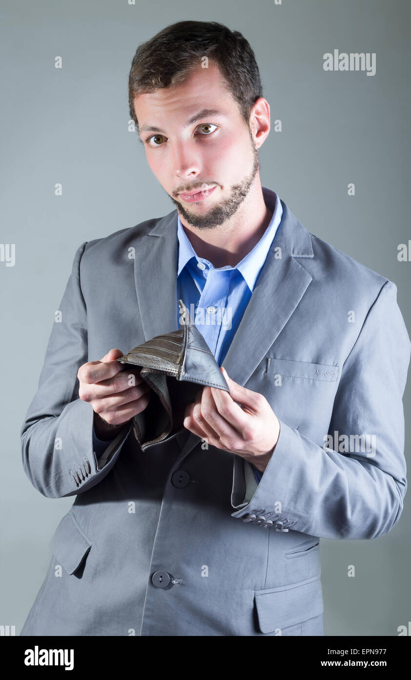 Portrait of young handsome man holding empty wallet Stock Photo - Alamy