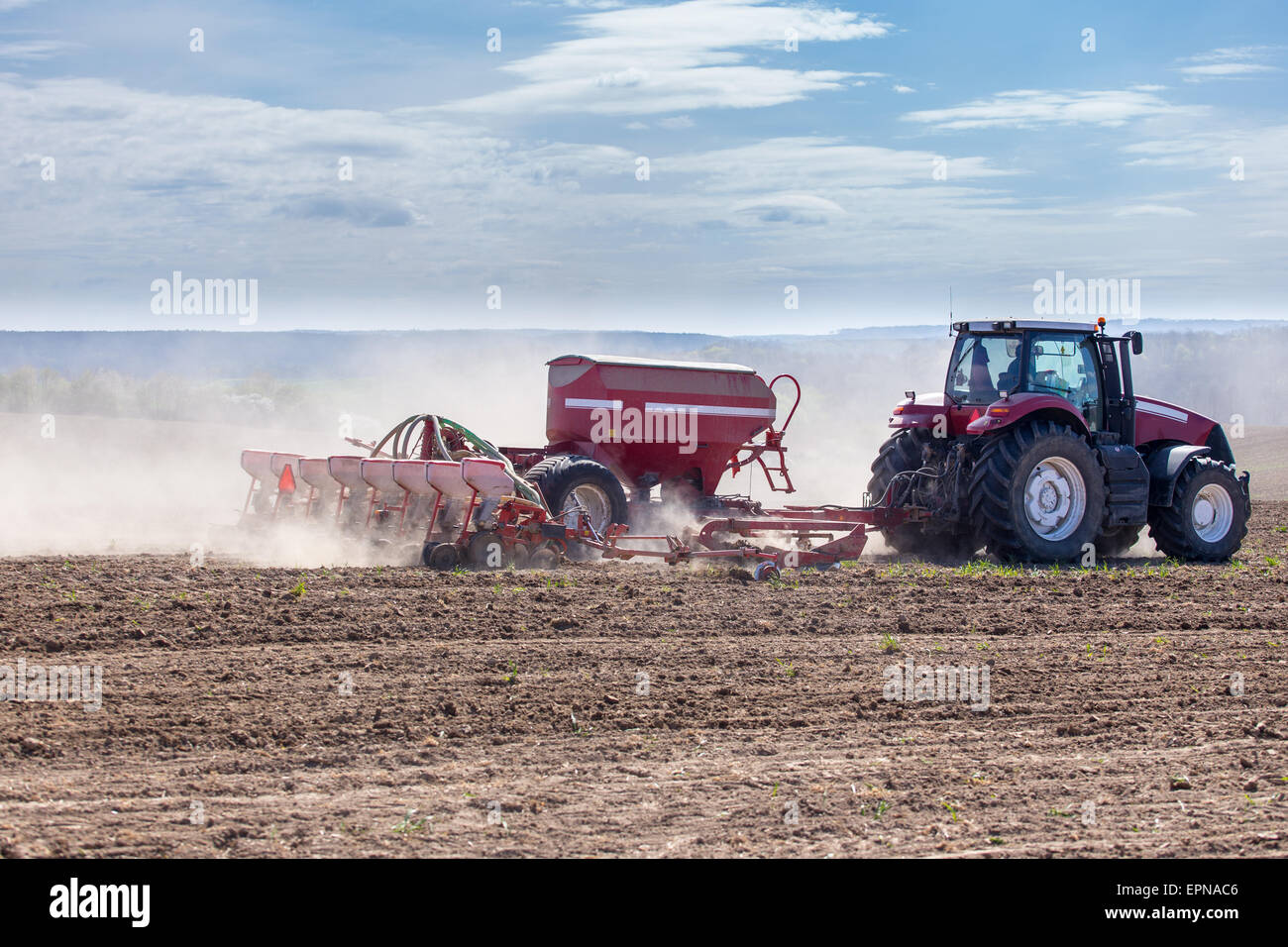 The tractor harrowing the large brown field in spring season Stock ...