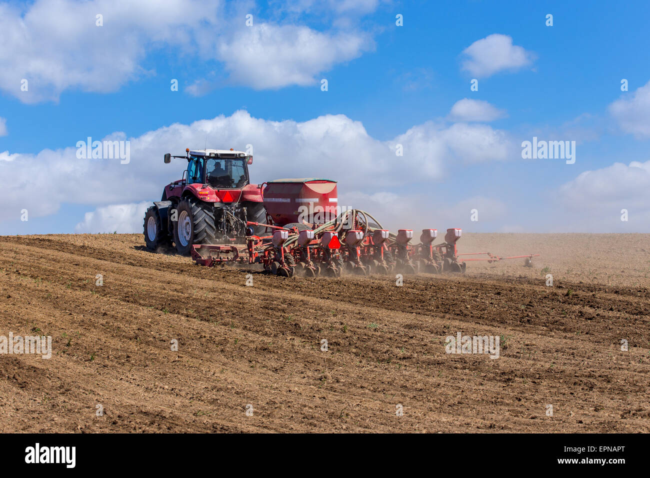 The tractor harrowing the large brown field in spring season Stock ...