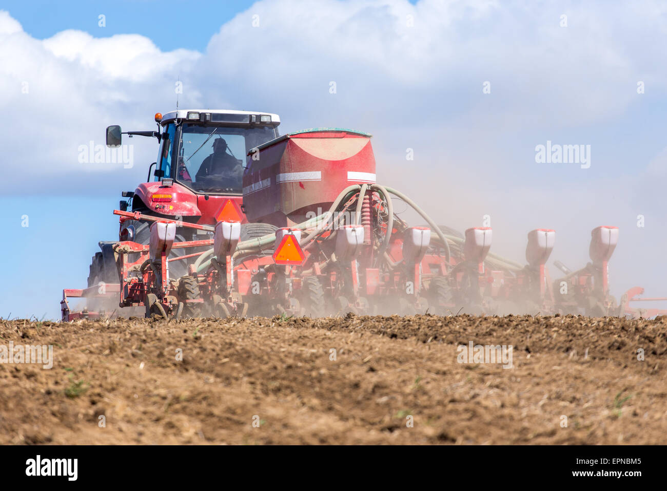 The tractor harrowing the large brown field in spring season Stock ...