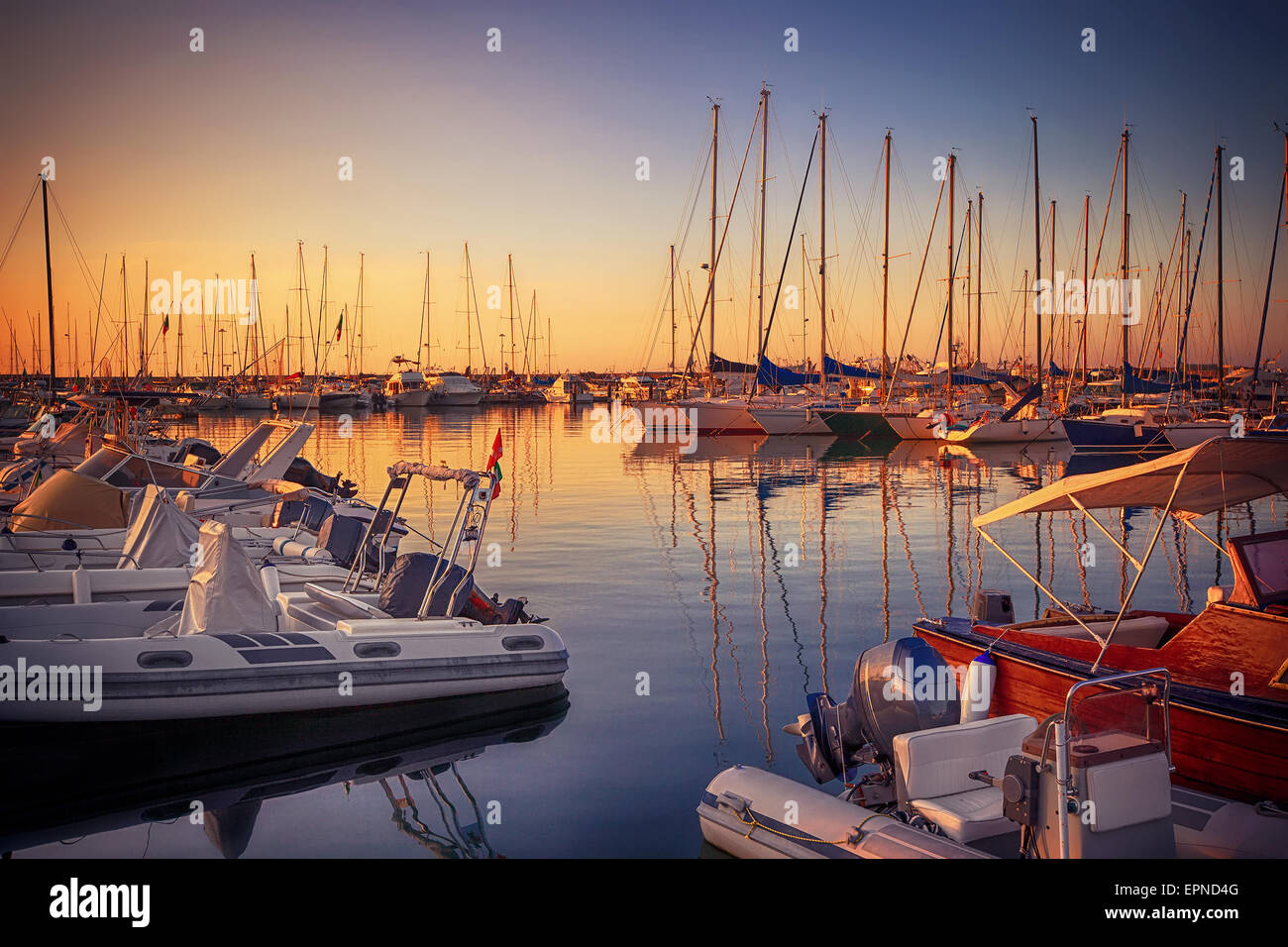 Marina with docked yachts at sunset Stock Photo - Alamy