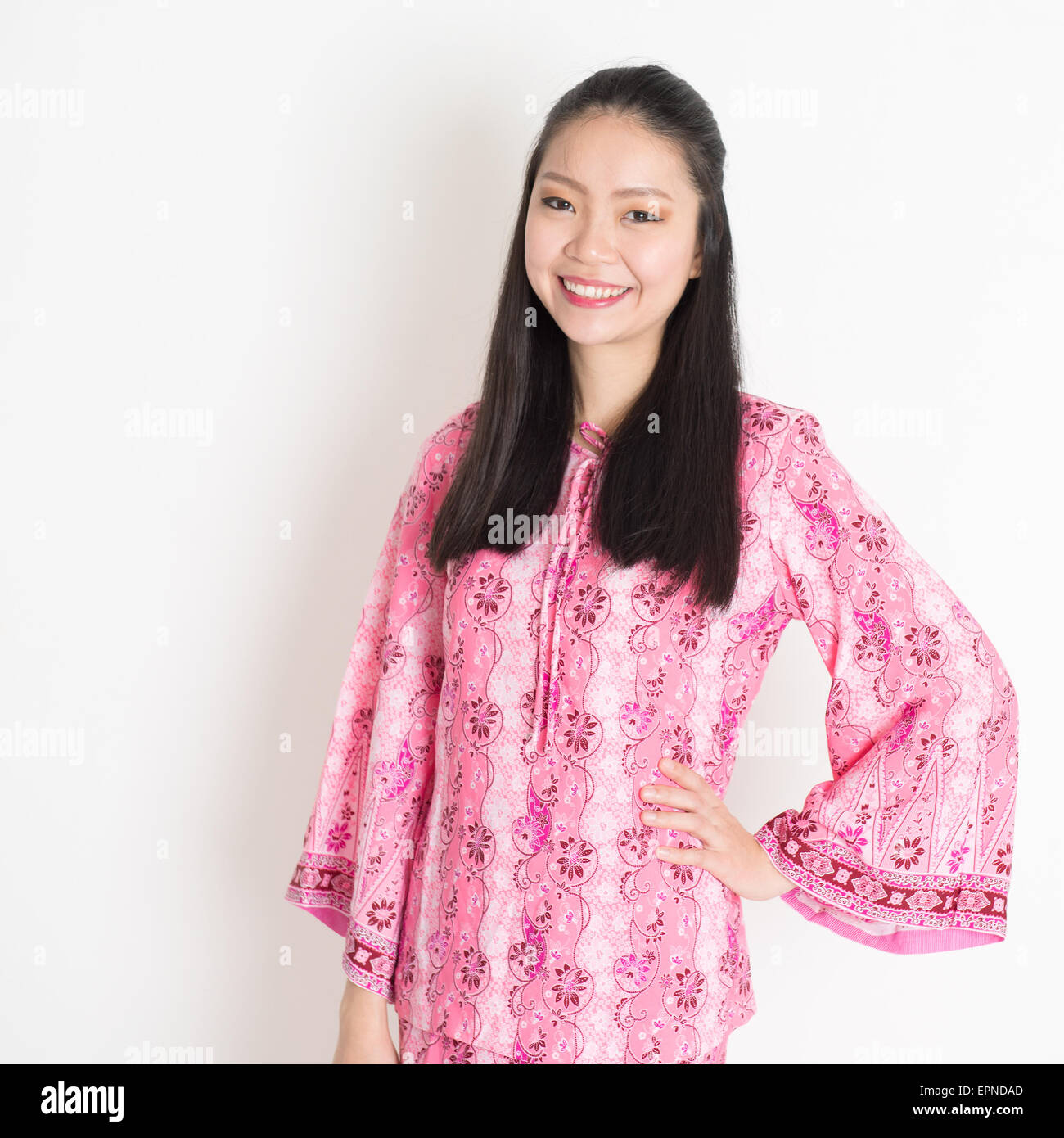 Portrait Of Happy Southeast Asian Woman In Pink Batik Dress Standing On