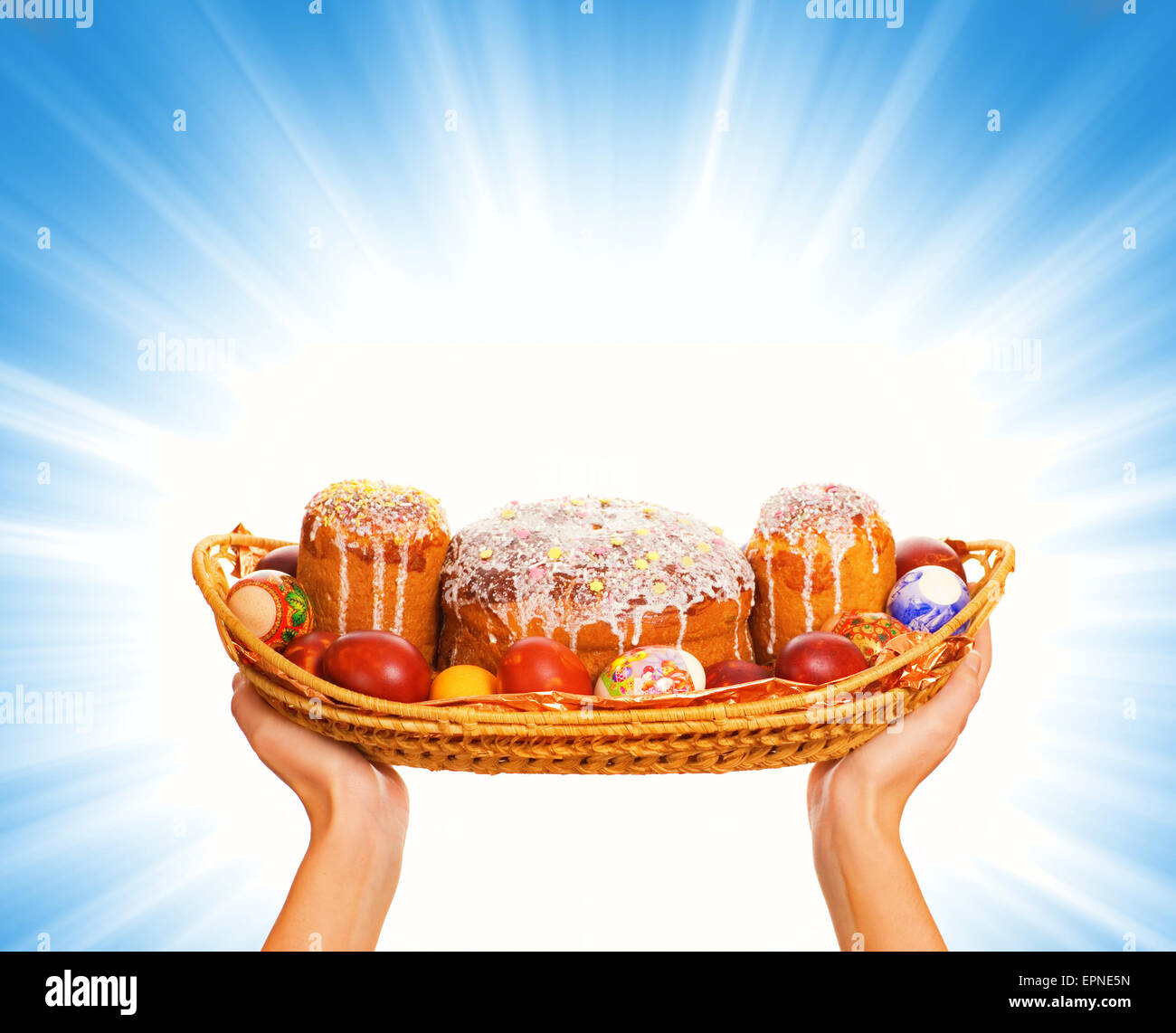 Hands holding woven basket full with easter eggs and easter cakes Stock ...