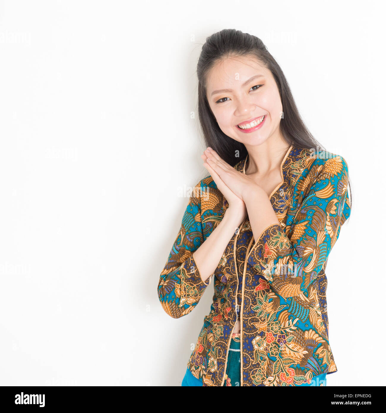 Portrait Of Happy Southeast Asian Woman In Batik Dress On Plain