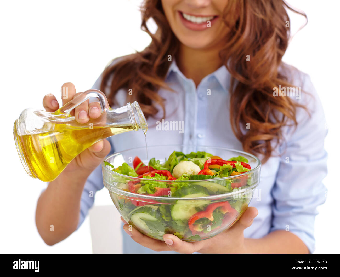 Happy girl adding olive oil in vegetable salad Stock Photo - Alamy