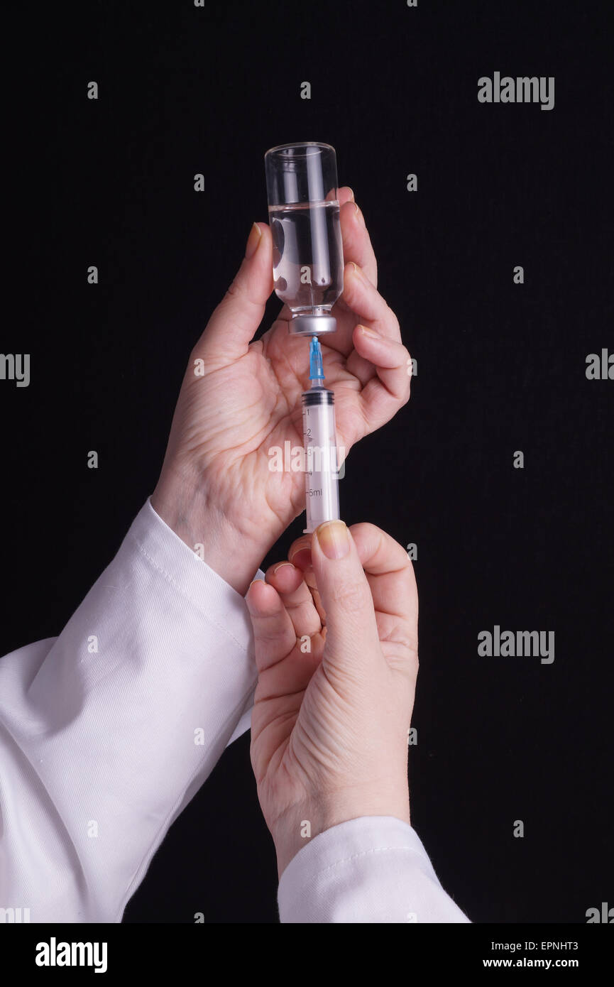 Filling of a syringe with medicine from vial. Medical person holding ...