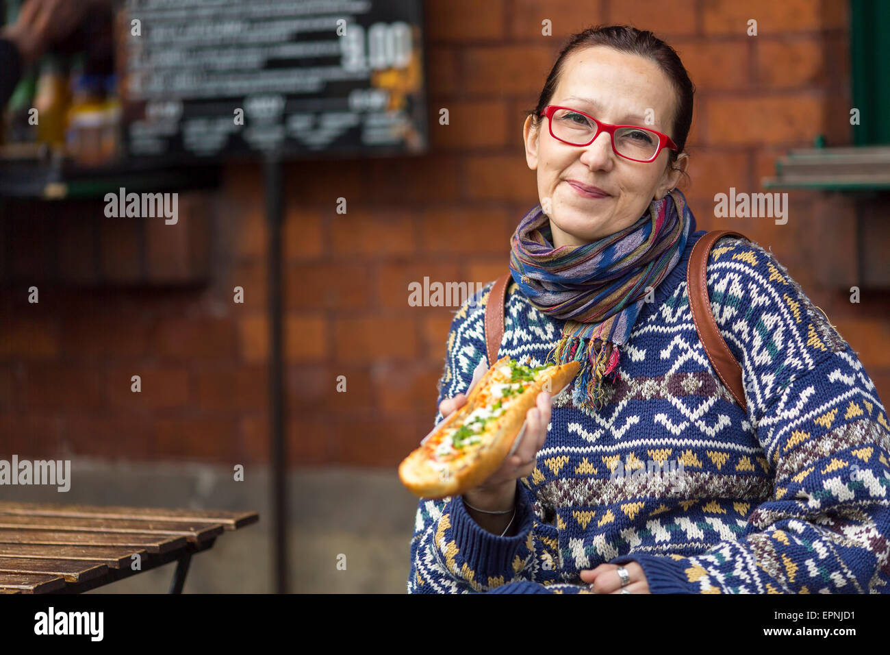 Woman eating Zapiekanka - Polish fast-food a casserole Stock Photo - Alamy