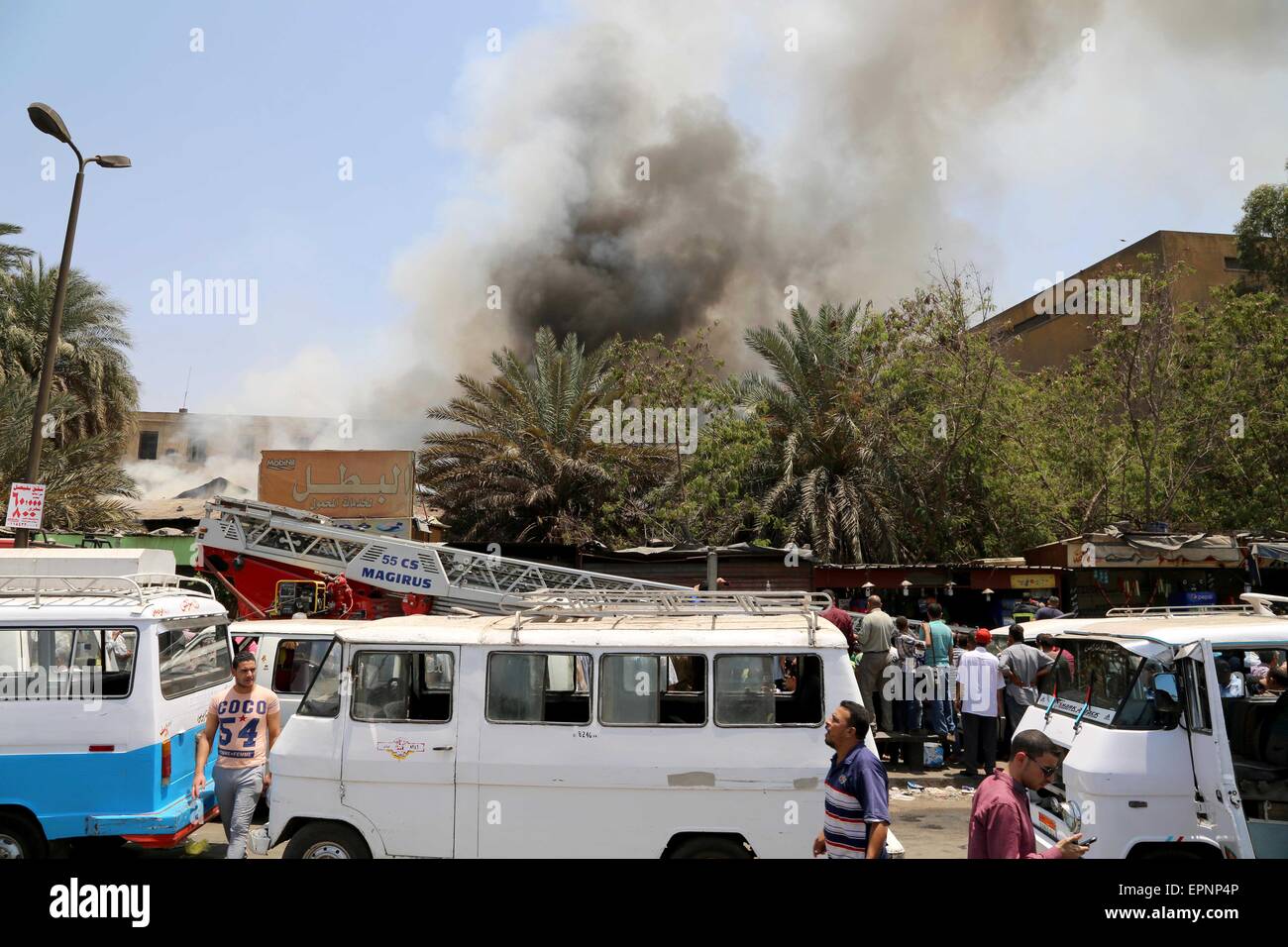 Cairo, Egypt. 20th May, 2015. Egyptians walk in a street as smoke ...
