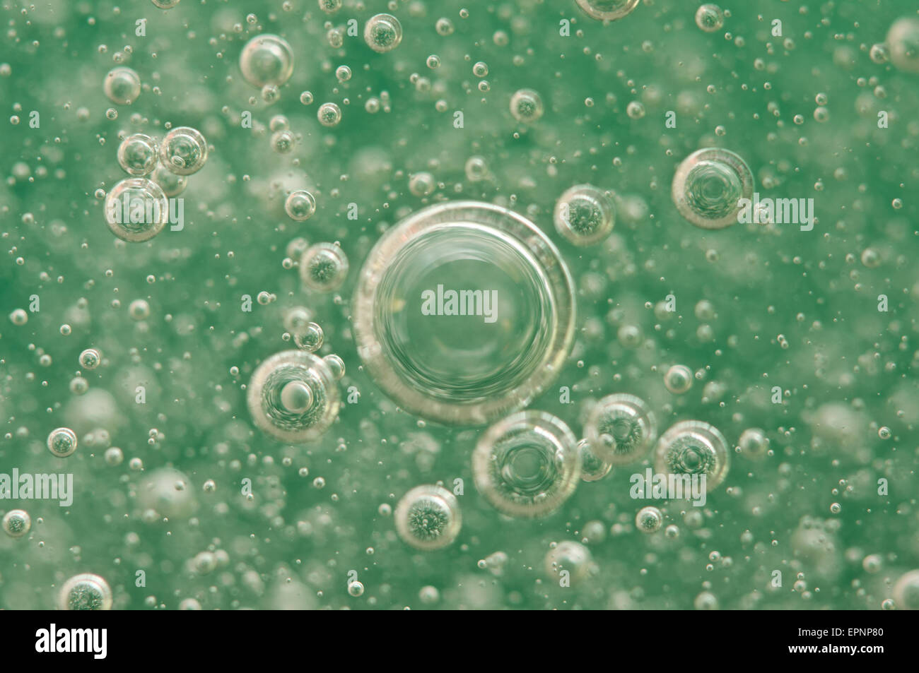 Macro Oxygen bubbles in water on a green background, concept such as ...
