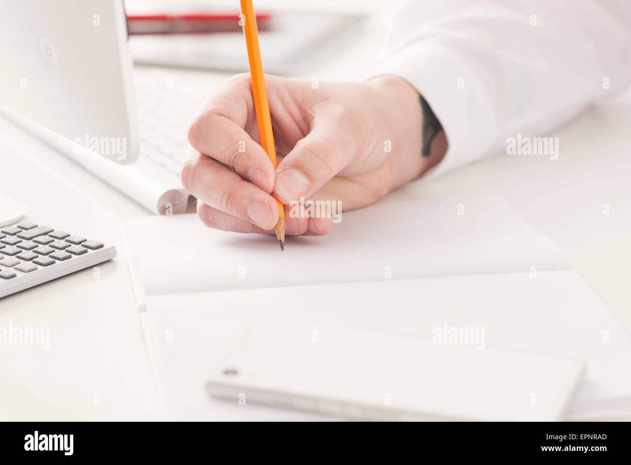 Office work. Businessman in office, writing with pencil in notebook ...