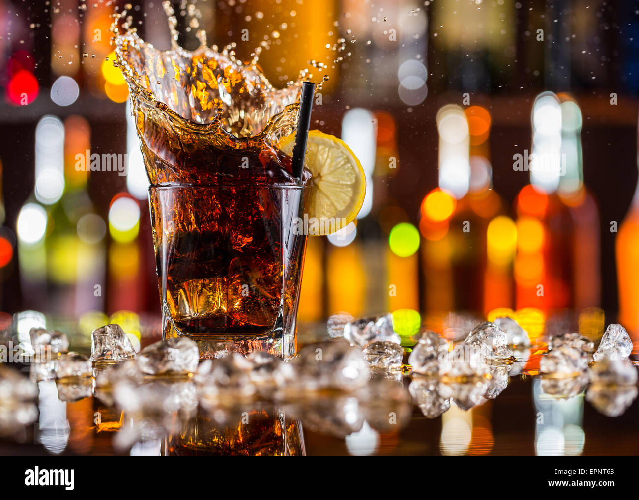 Glass of cola drink on bar counter with ice cubes and splash Stock ...