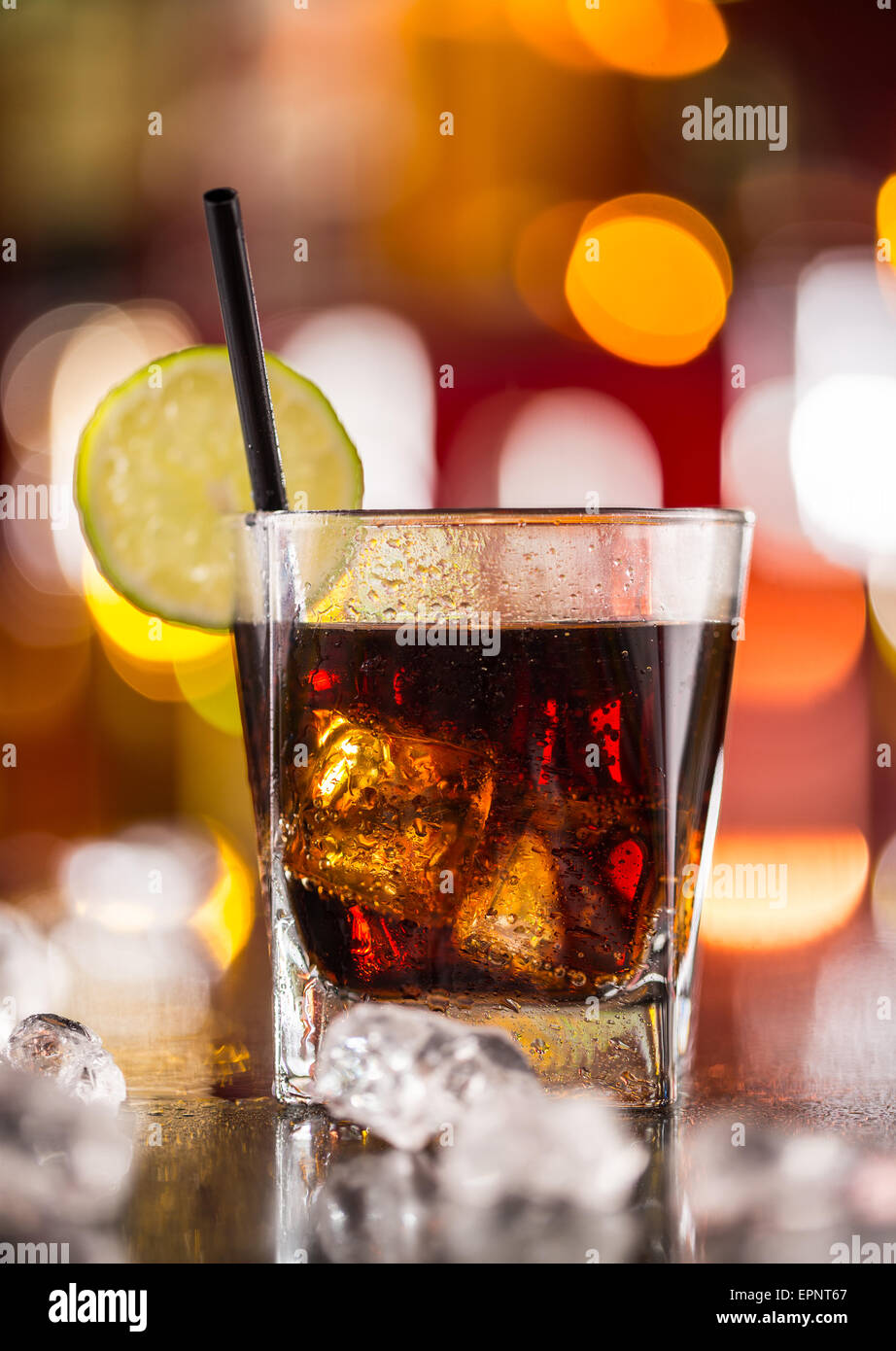 Glass of cola drink on bar counter with ice cubes Stock Photo - Alamy