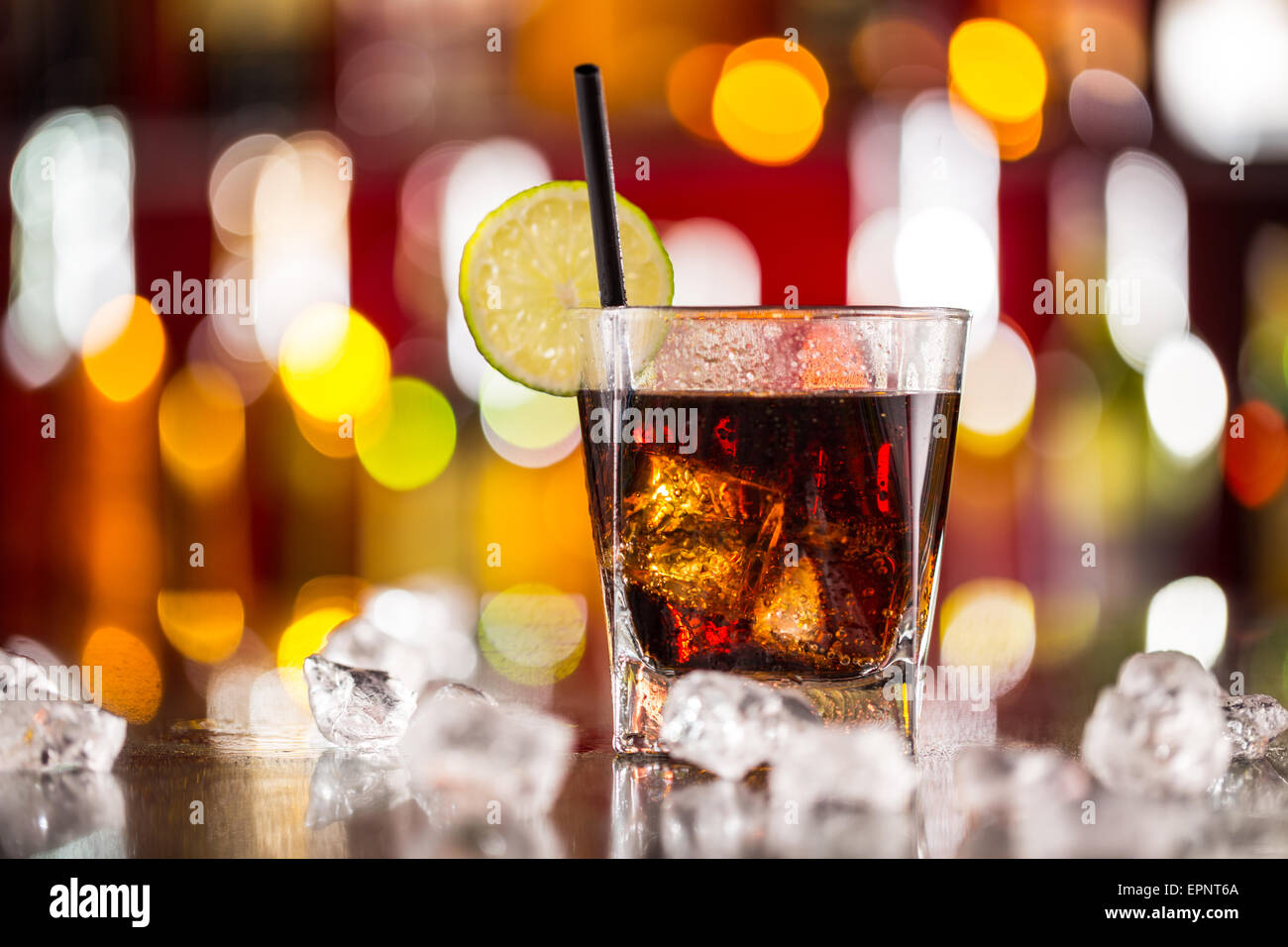 Glass of cola drink on bar counter with ice cubes Stock Photo - Alamy