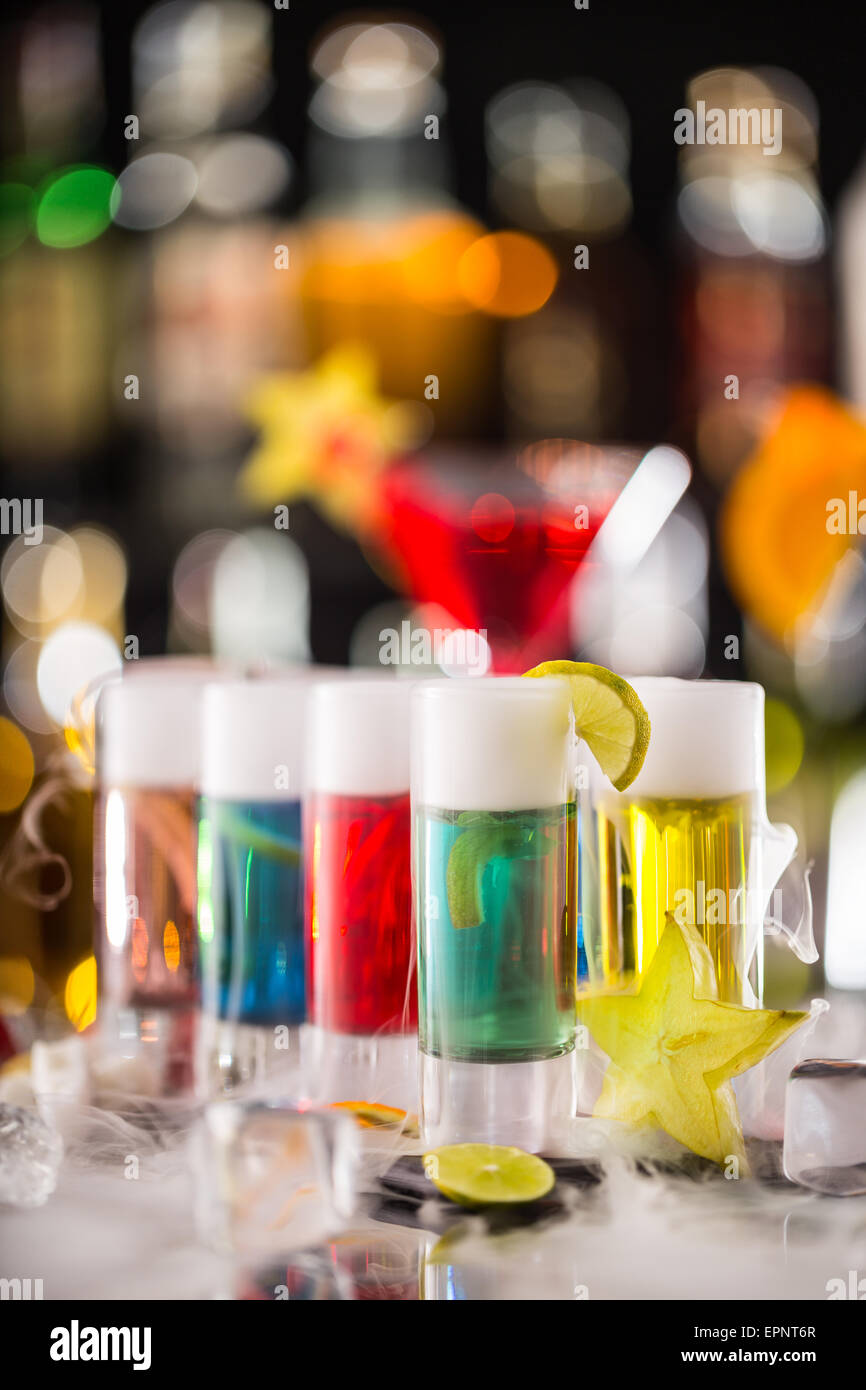 Variation of hard alcoholic shots with dry ice smoke effect, served on ...