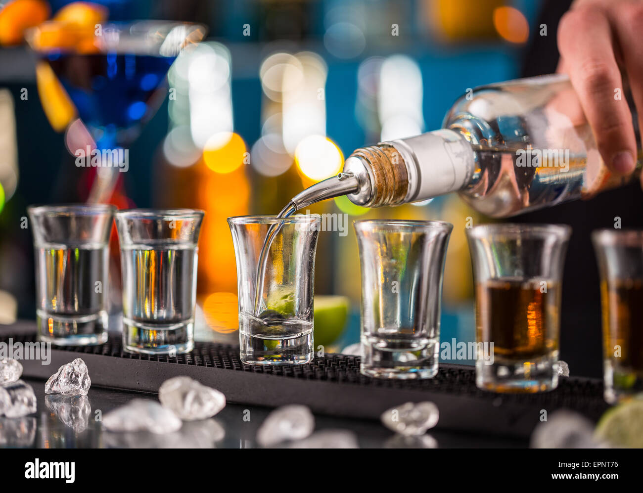 Barman pouring hard spirit into glasses in detail Stock Photo - Alamy