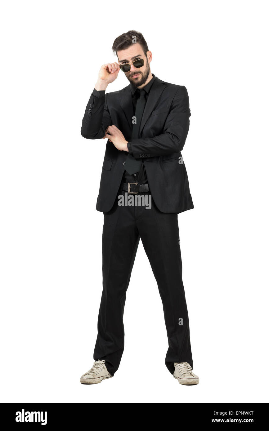 Suspicious young bearded man looking above sunglasses. Full body length ...