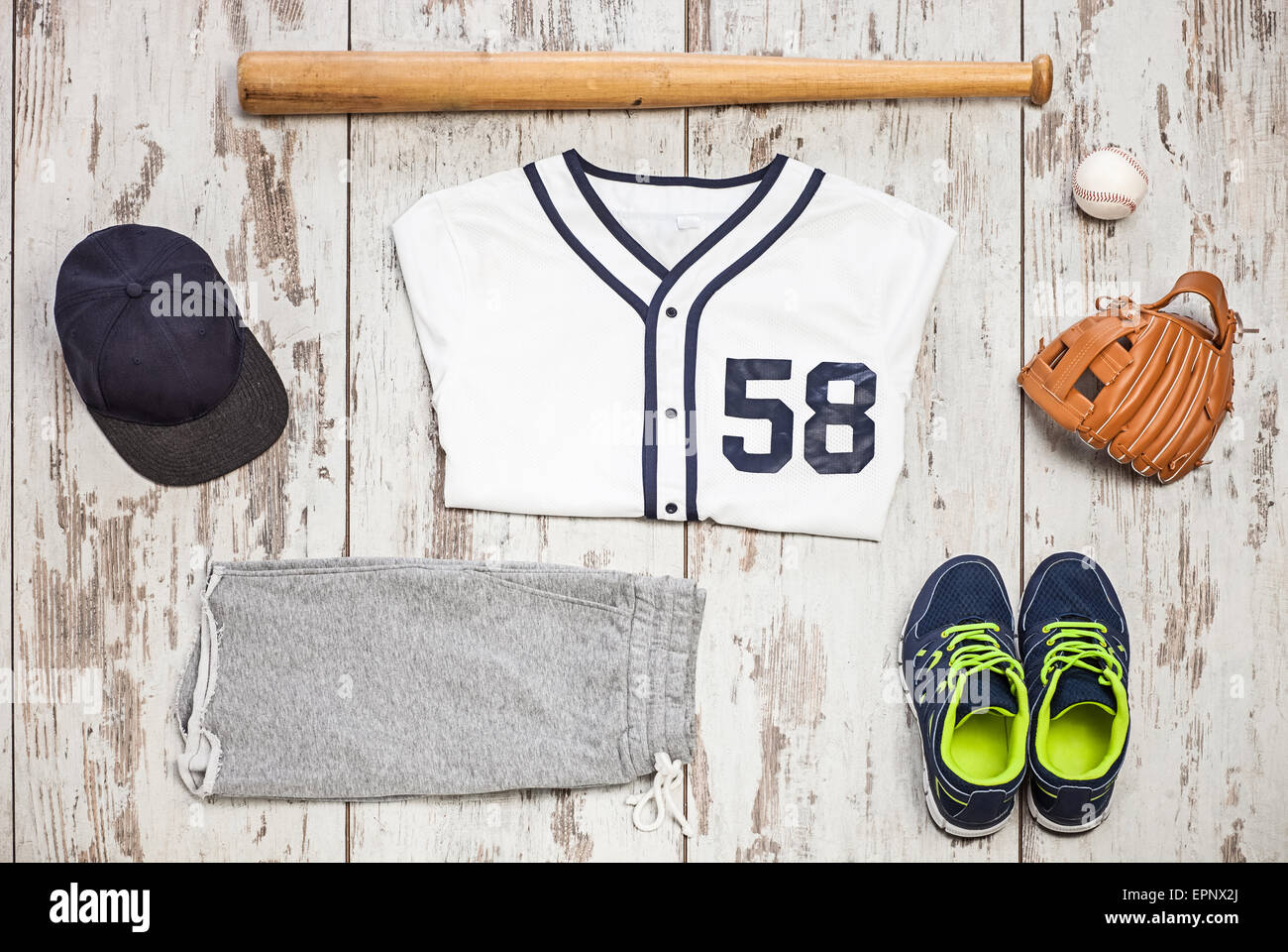 Bunch of sportswear and baseball equipment on a white hardwood floor ...