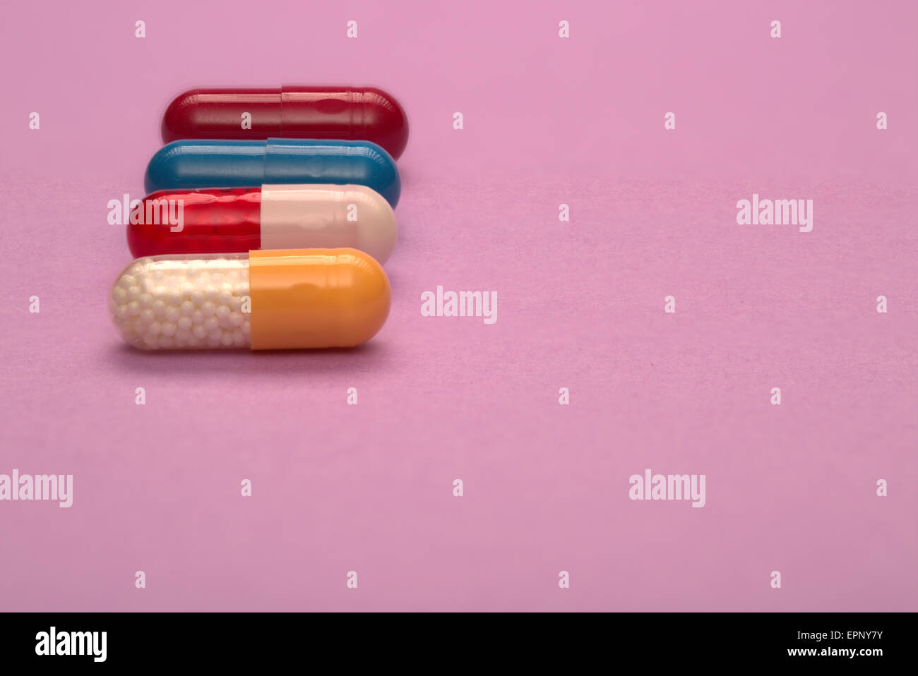 Color medical capsules text space on pink background Stock Photo - Alamy
