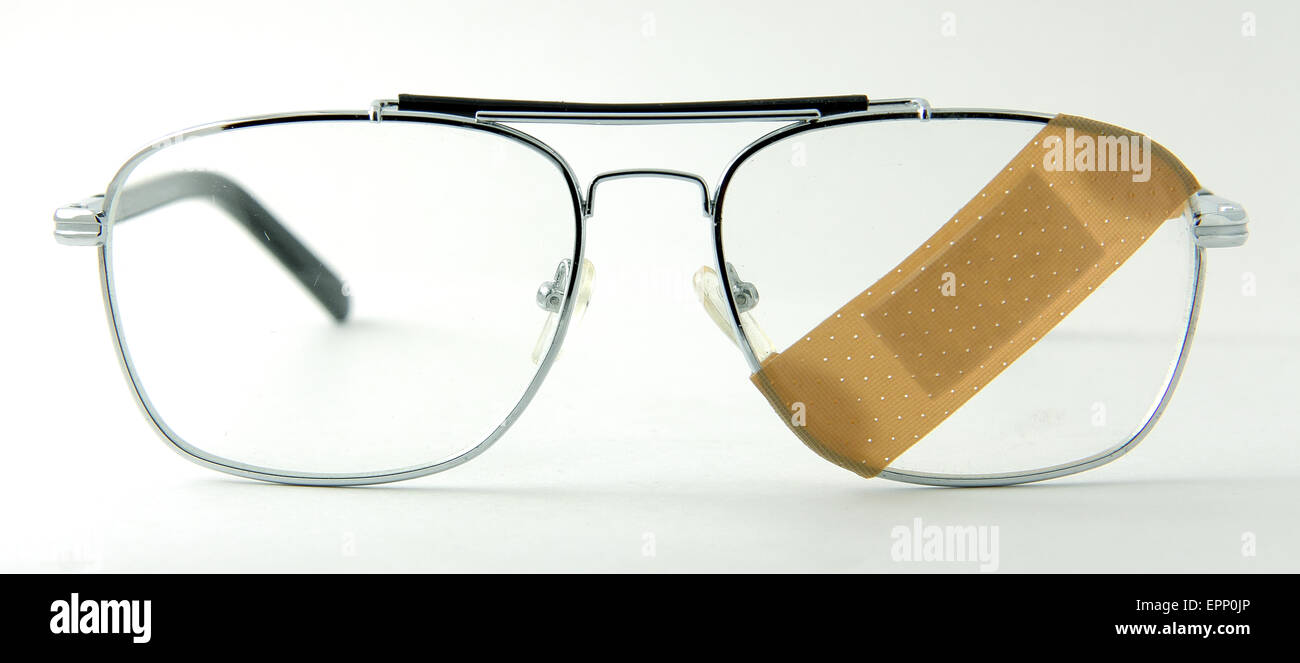 Eye glasses with a band-aid Stock Photo - Alamy