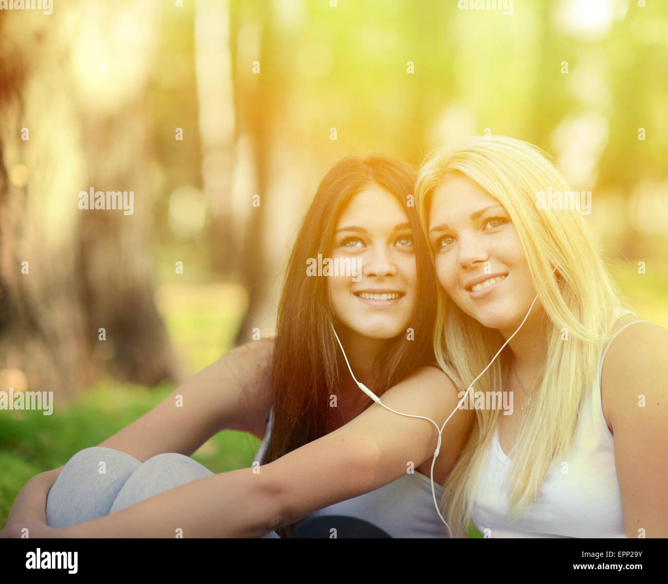 Happy teenage girls listening to music outdoors Stock Photo - Alamy