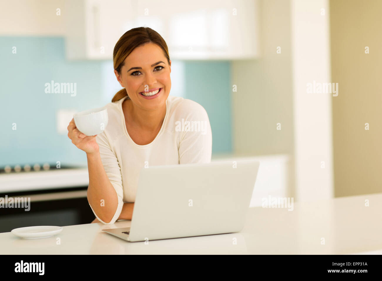 woman in kitchen using laptop computer Stock Photo - Alamy