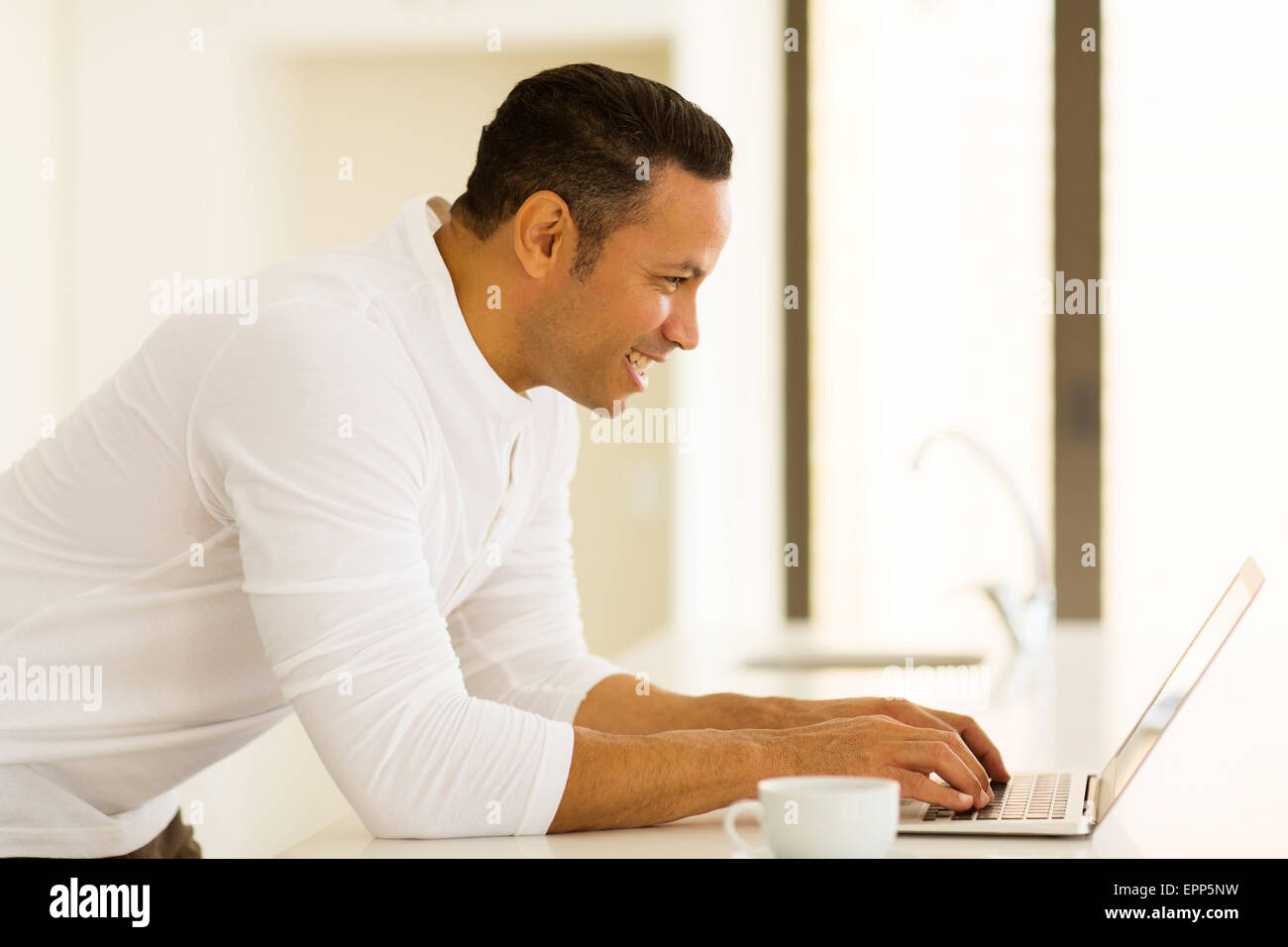happy man using laptop in the kitchen Stock Photo - Alamy