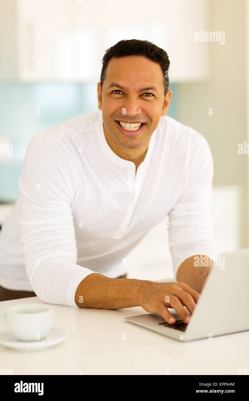 happy middle aged man using laptop computer on kitchen counter Stock ...